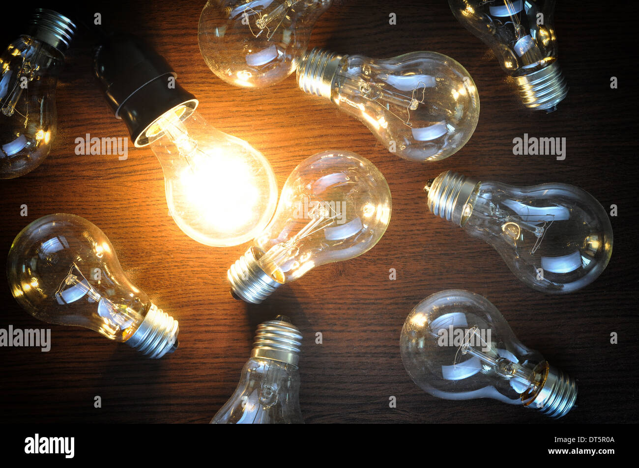 idea concept with glowing bulb on brown wooden background Stock Photo ...