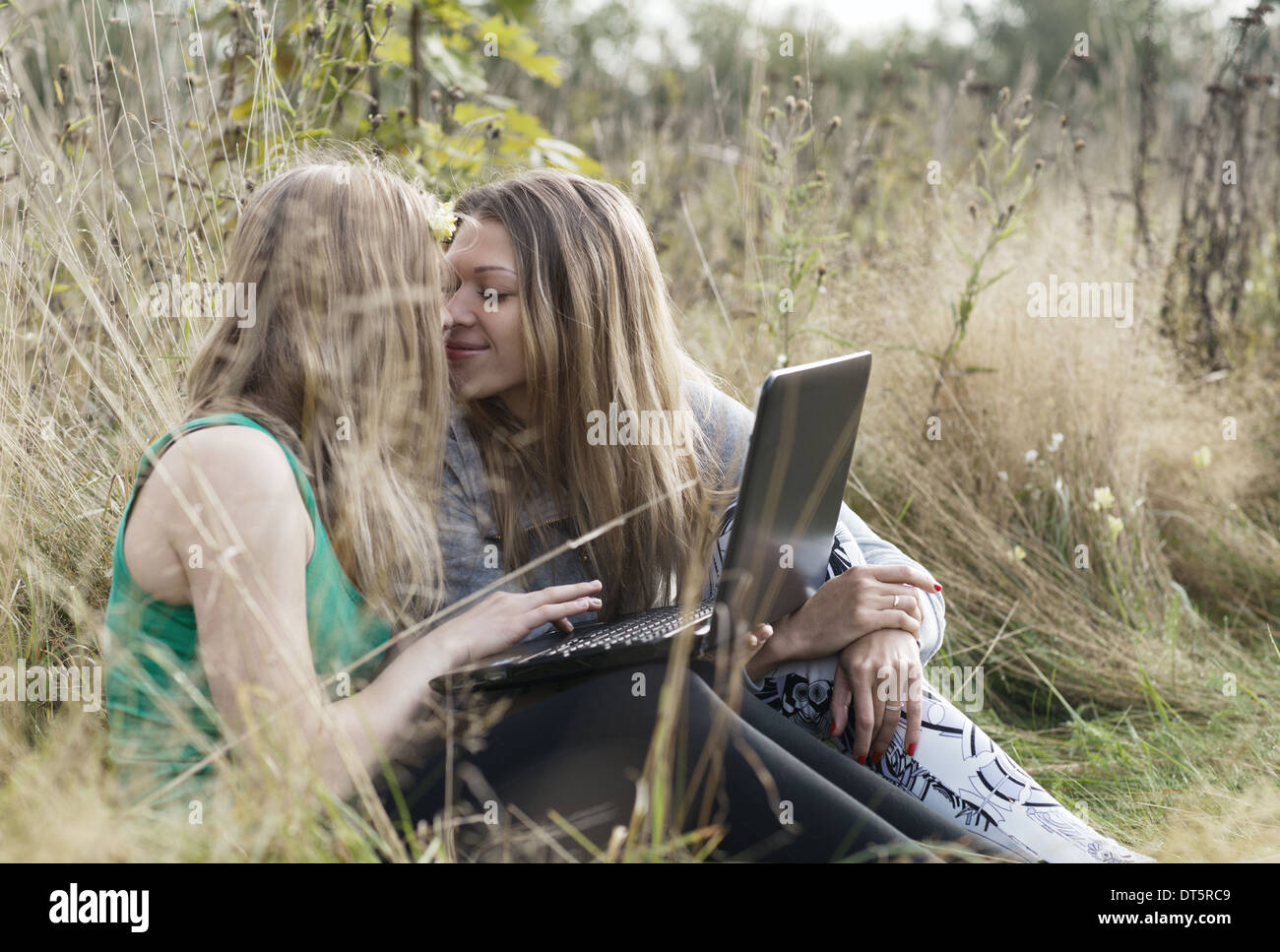 Two women friends sitting outdoors together Stock Photo - Alamy