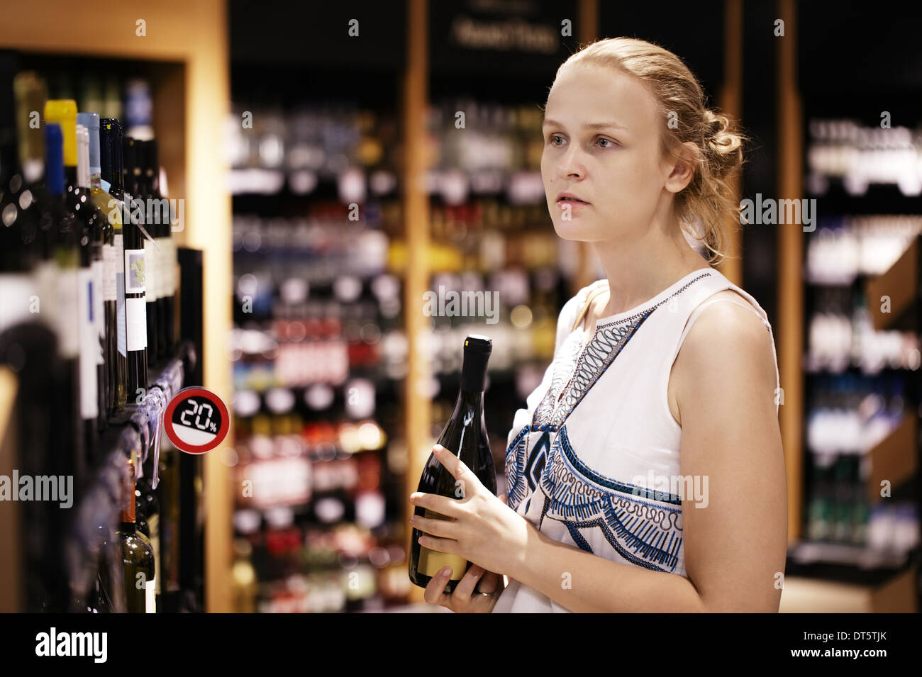 Woman shopping for alcohol in a bottle store Stock Photo - Alamy