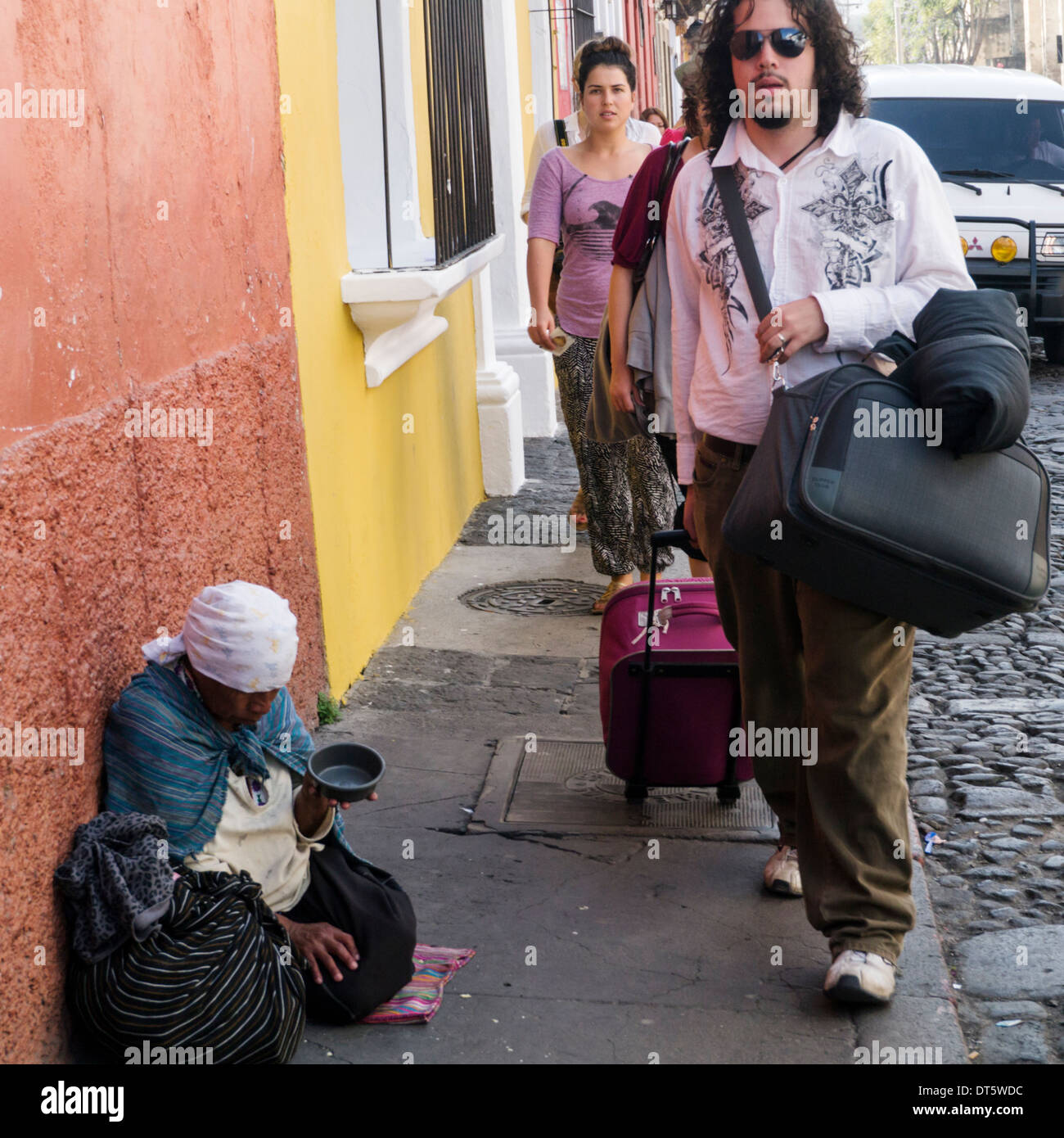 Tourists walking past a beggar hi-res stock photography and images - Alamy