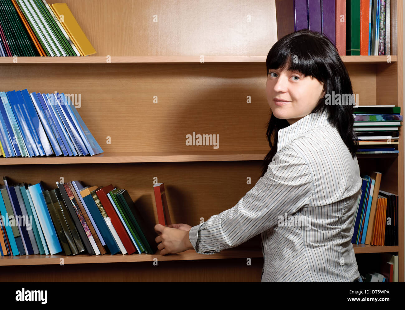 Young woman picking out several books for pleasure reading Stock Photo ...