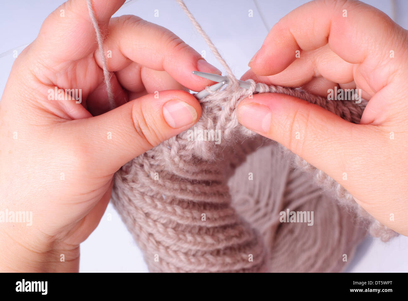 Knitting hands close up with woven thread Stock Photo - Alamy