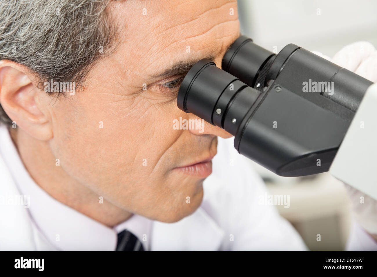 Mature scientist using microscope hi-res stock photography and images ...