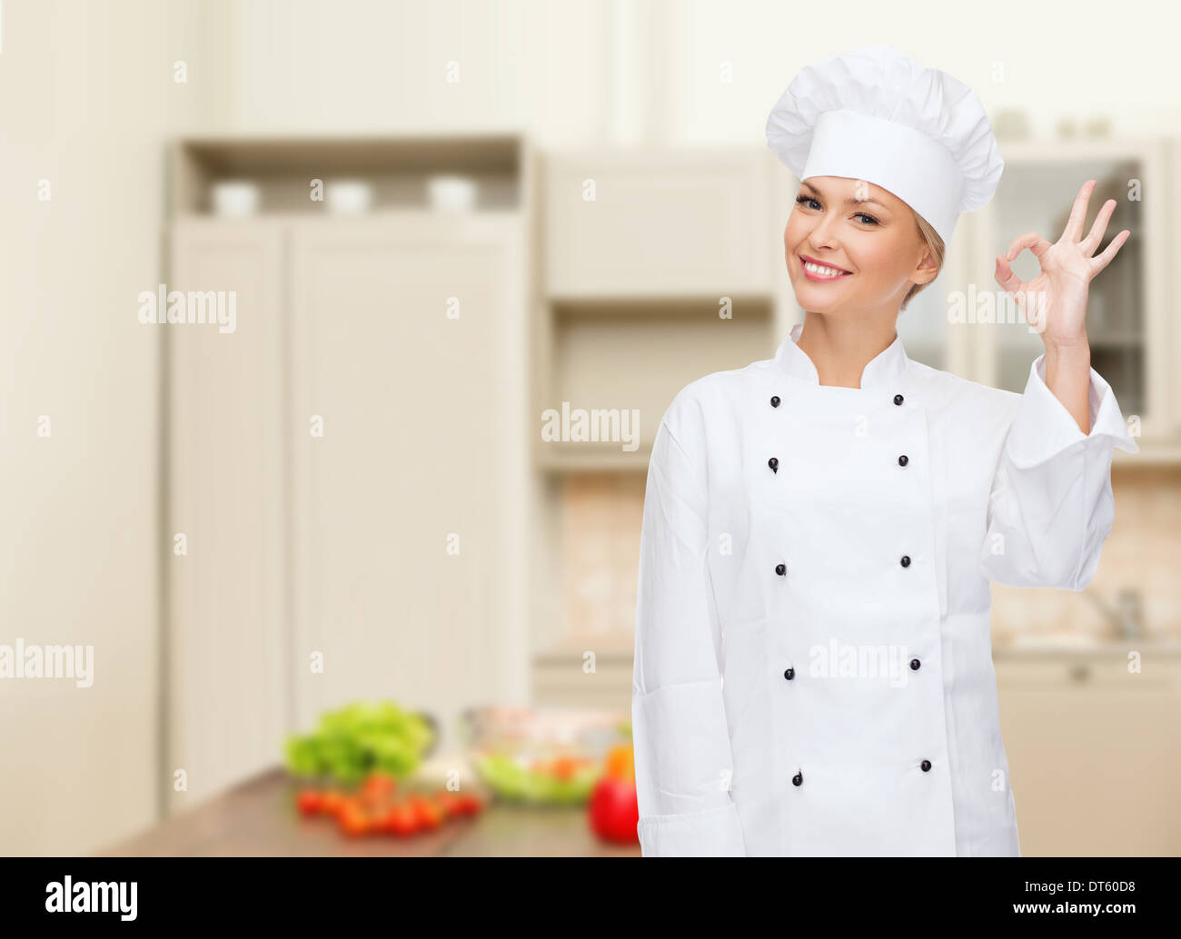 smiling female chef showing ok hand sign Stock Photo - Alamy