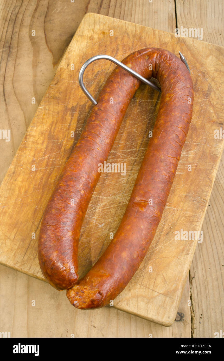 hungarian kolbasz with butcher hook on wooden board Stock Photo - Alamy
