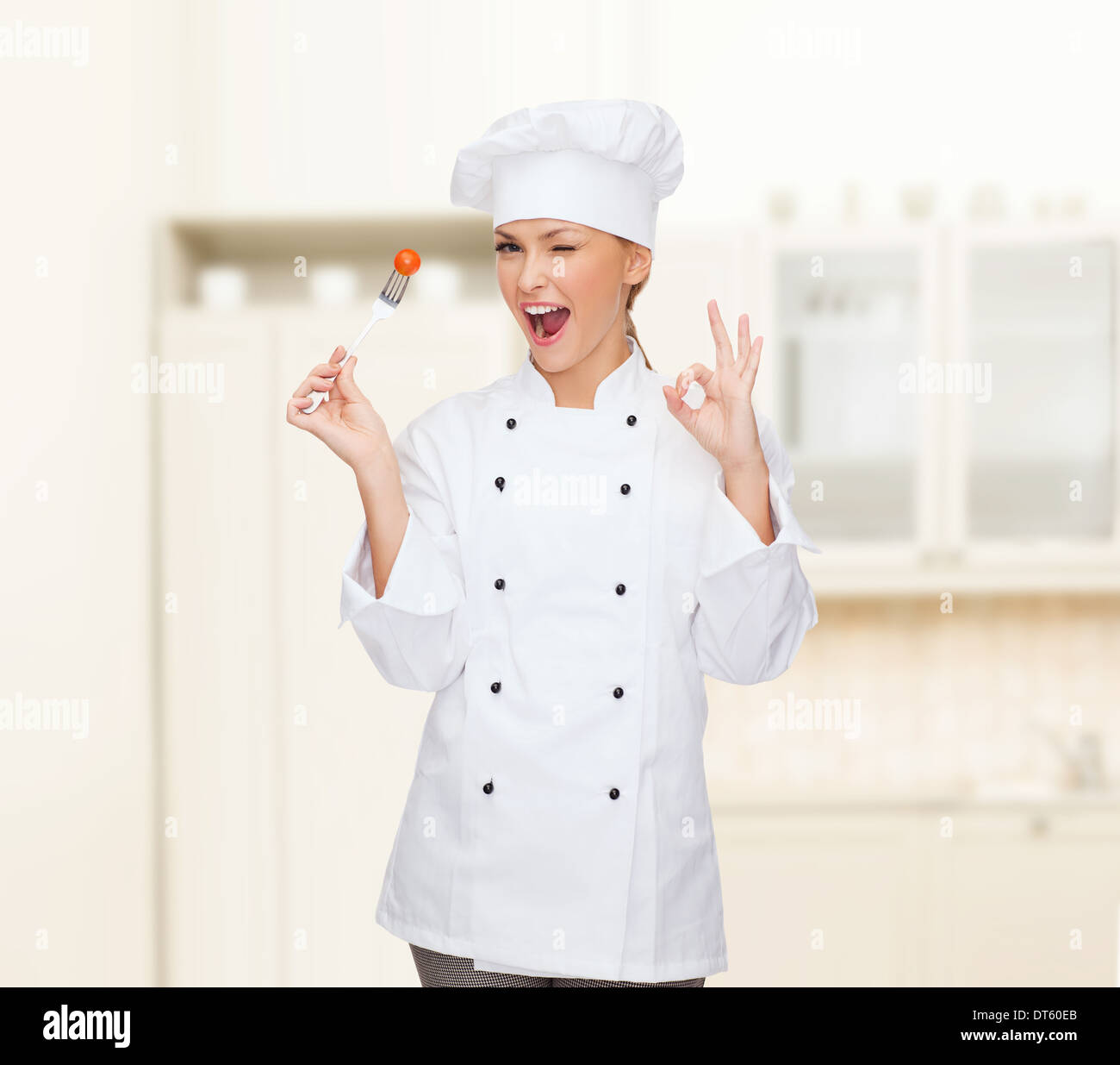 smiling female chef with fork and tomato Stock Photo - Alamy