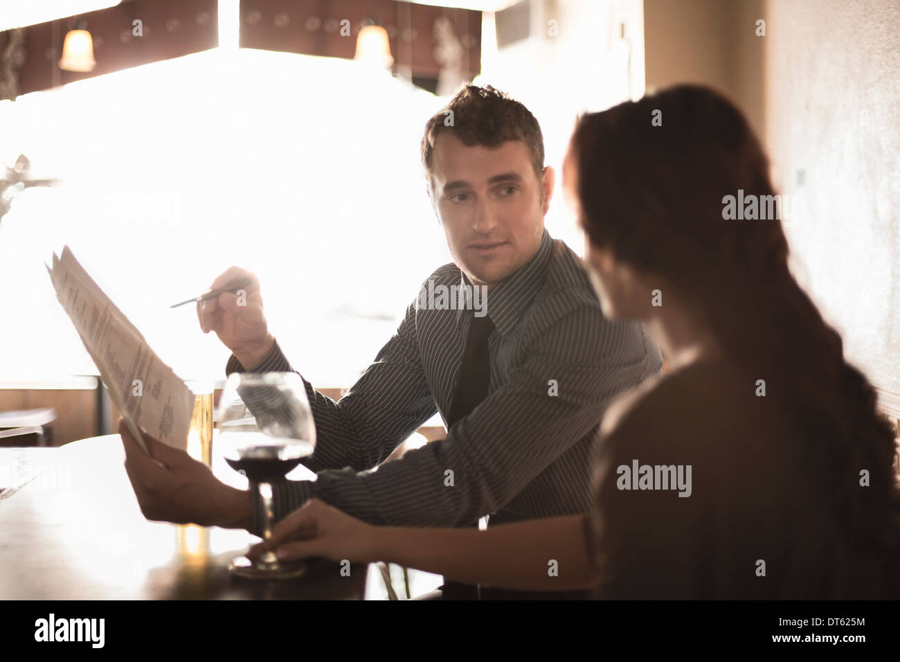Business partners looking at contract in a wine bar Stock Photo - Alamy