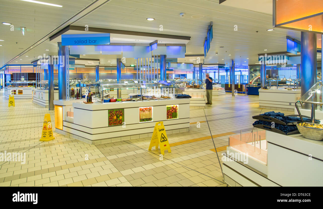 An empty cafeteria on a cruise ship early morning with a man drinking ...