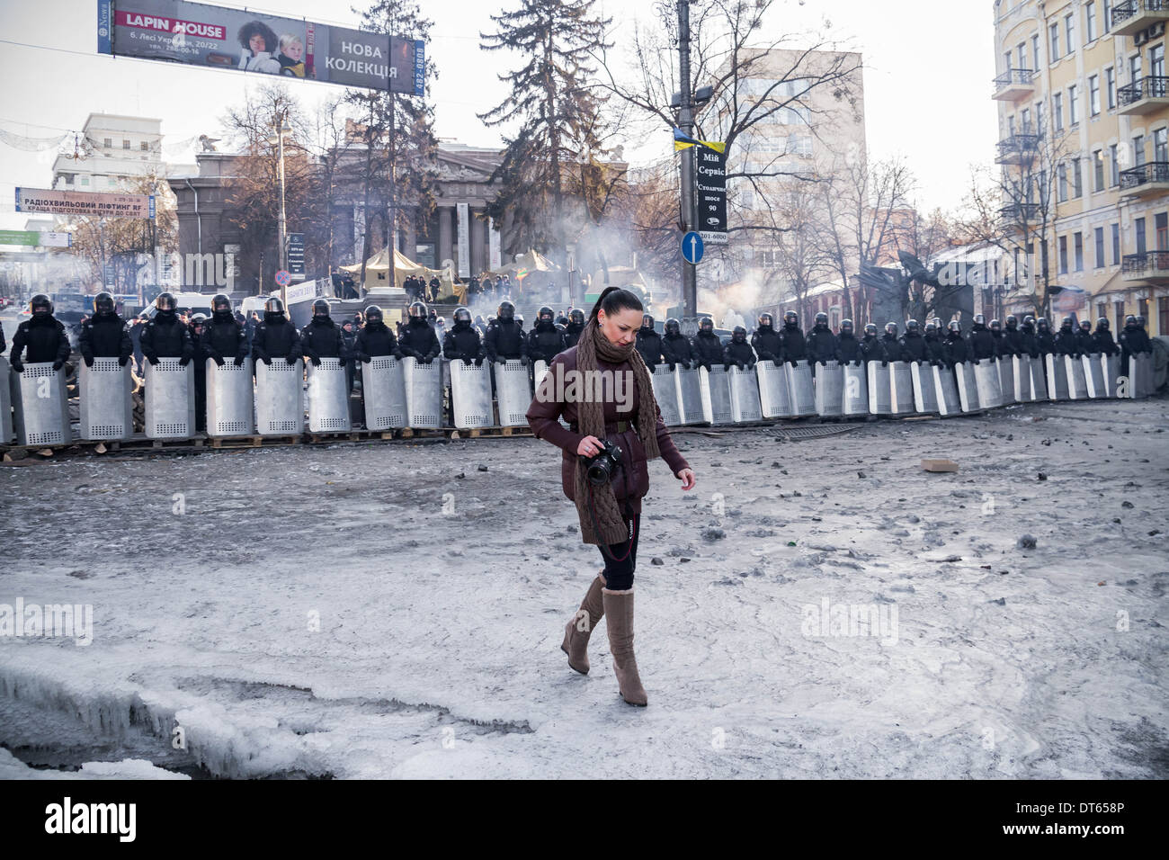 A local lady takes a photo of the riot police line over the barricades ...
