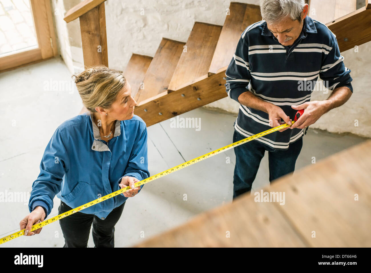Senior couple doing DIY, using measuring tape Stock Photo - Alamy