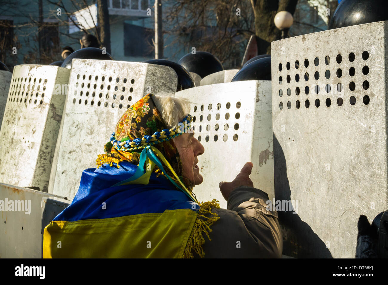 A women Euromaidan protester confronts rows of government riot police ...