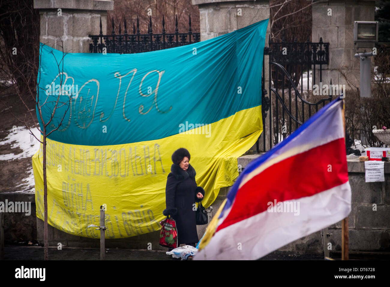 A women walks past protester Ukrainian and Belarusian flags on ...