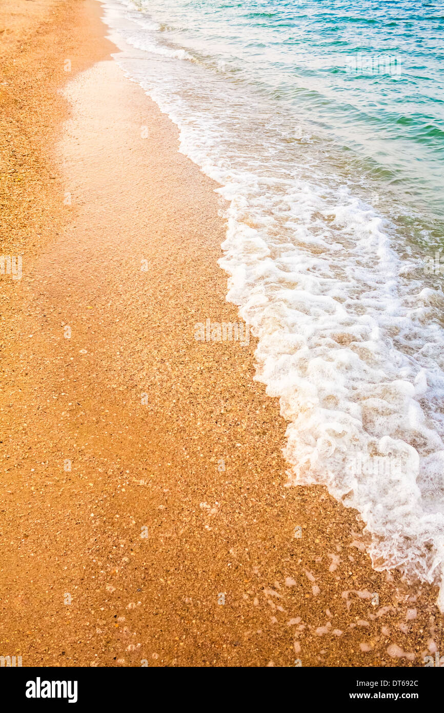 Sea ocean waves wash over yellow sand background Stock Photo - Alamy