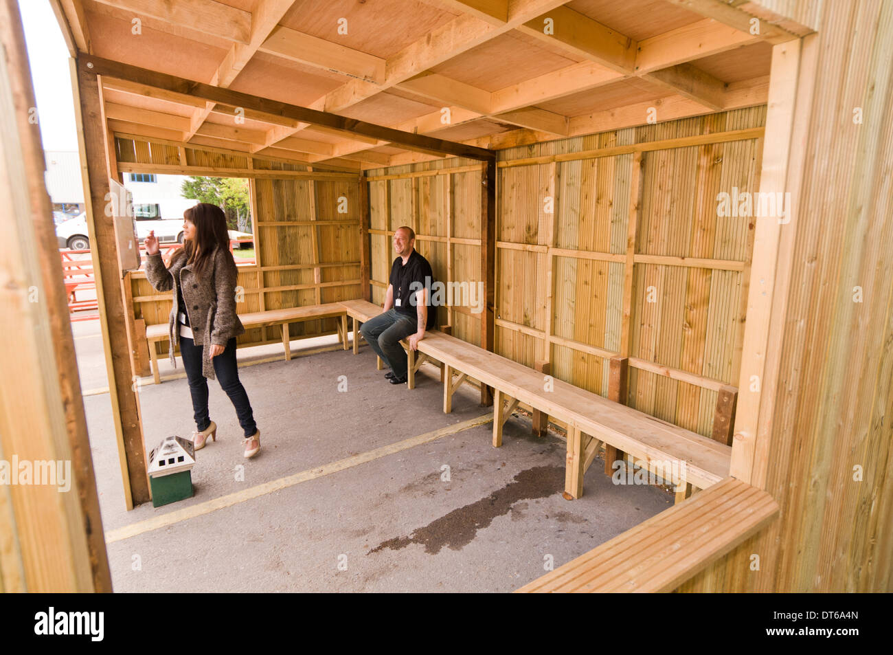 Man and a woman talking in a timber smokers shelter Stock Photo - Alamy