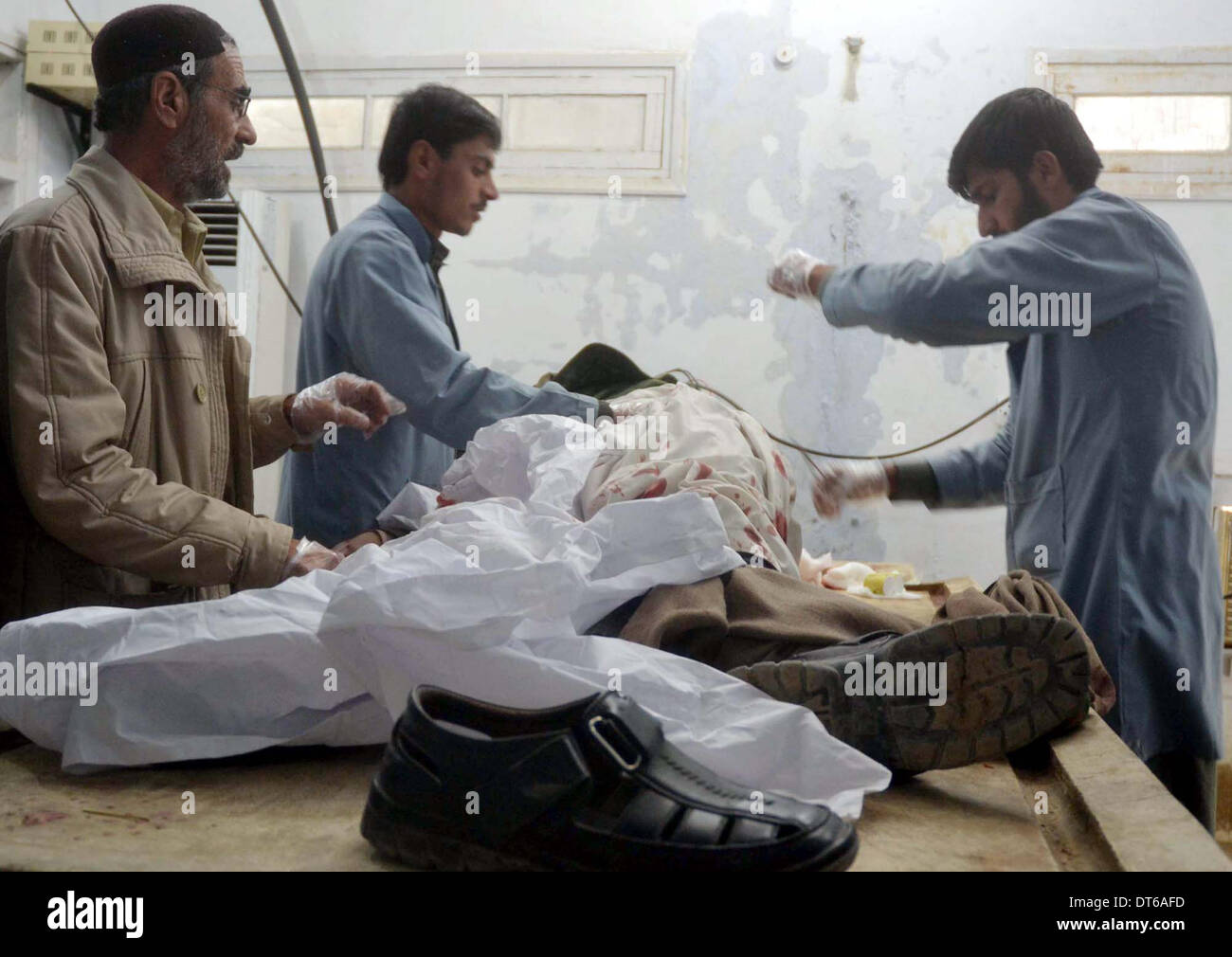 Paramedical staffs examine the dead body of an unknown man who gunned ...