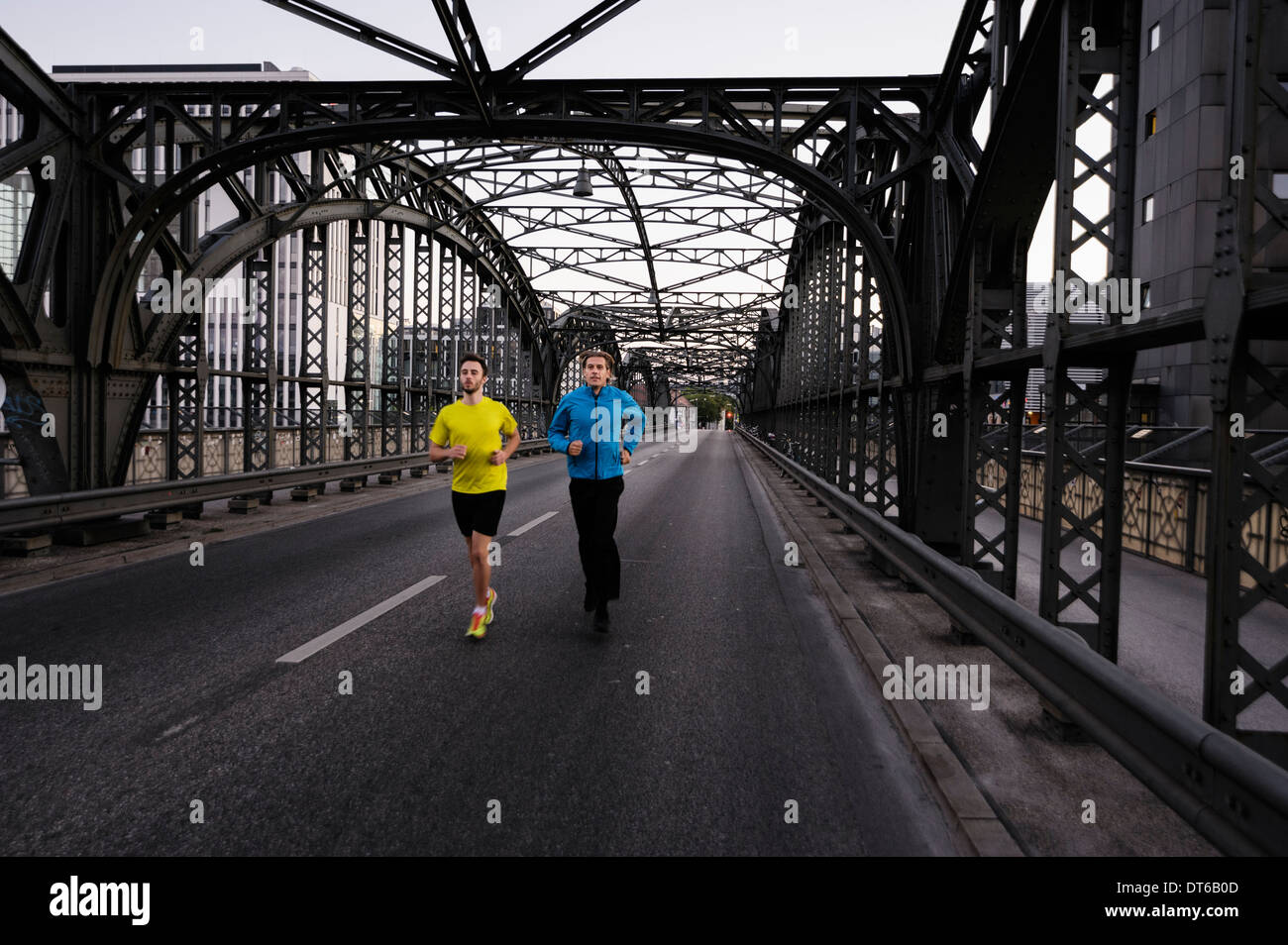 Two men running over city bridge Stock Photo - Alamy