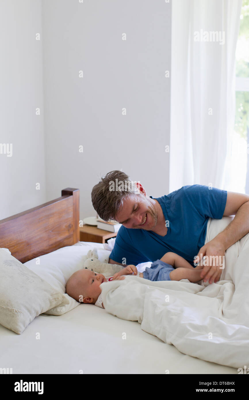 Father playing with baby daughter on bed Stock Photo - Alamy