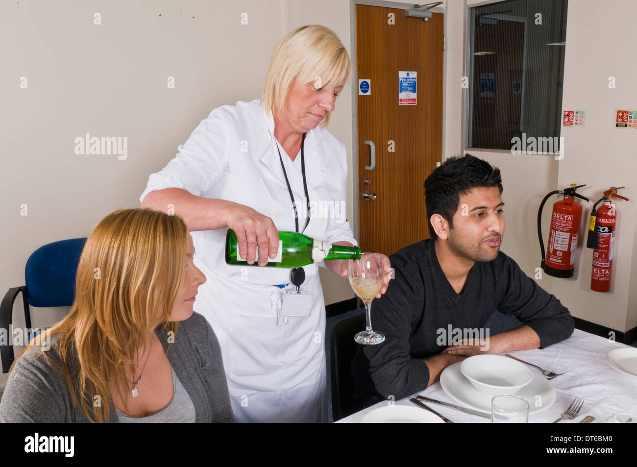 Group of people sat around a dinner table ordering food Stock Photo - Alamy