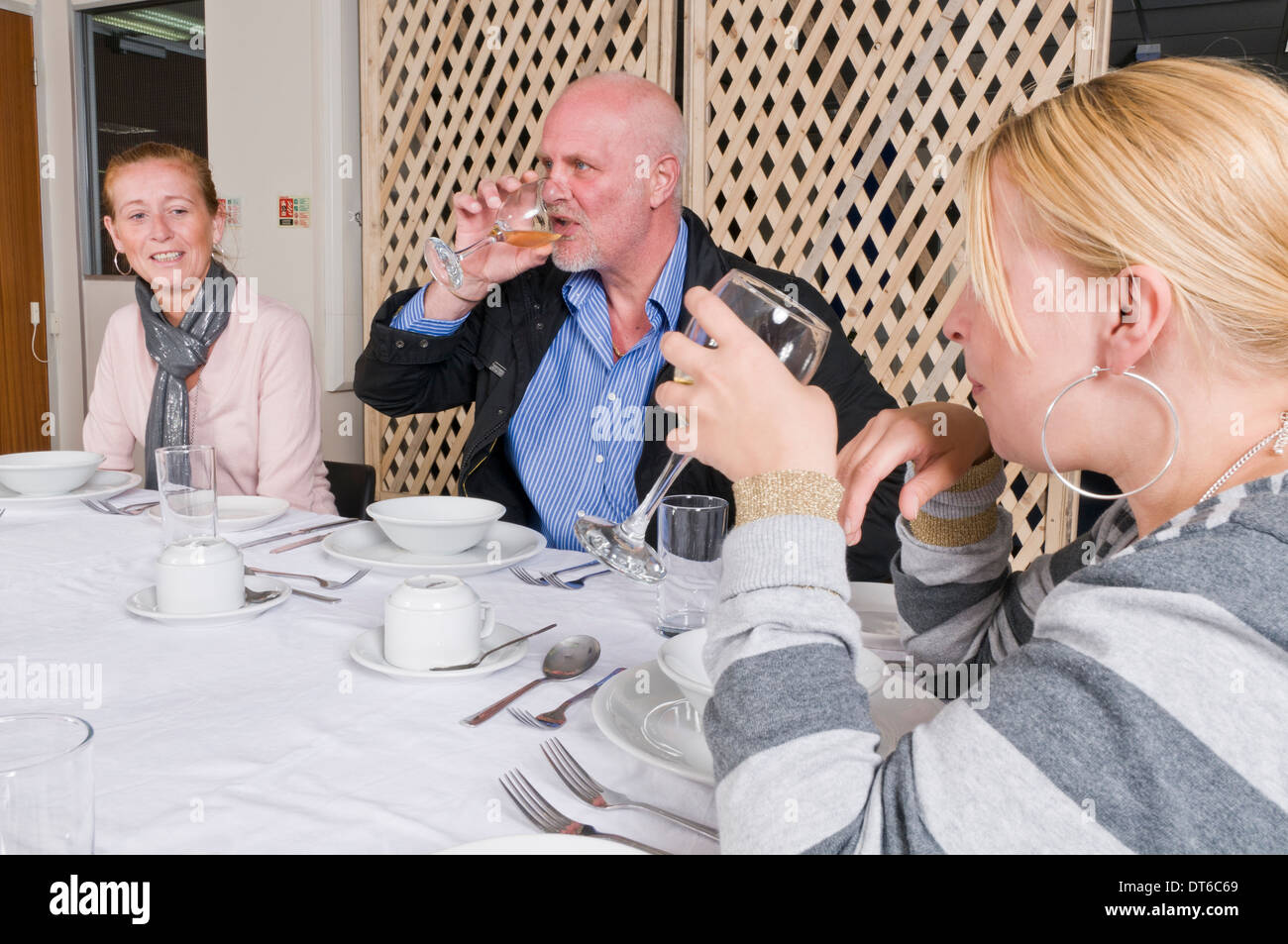 Group of people sat around a dinner table ordering food Stock Photo - Alamy