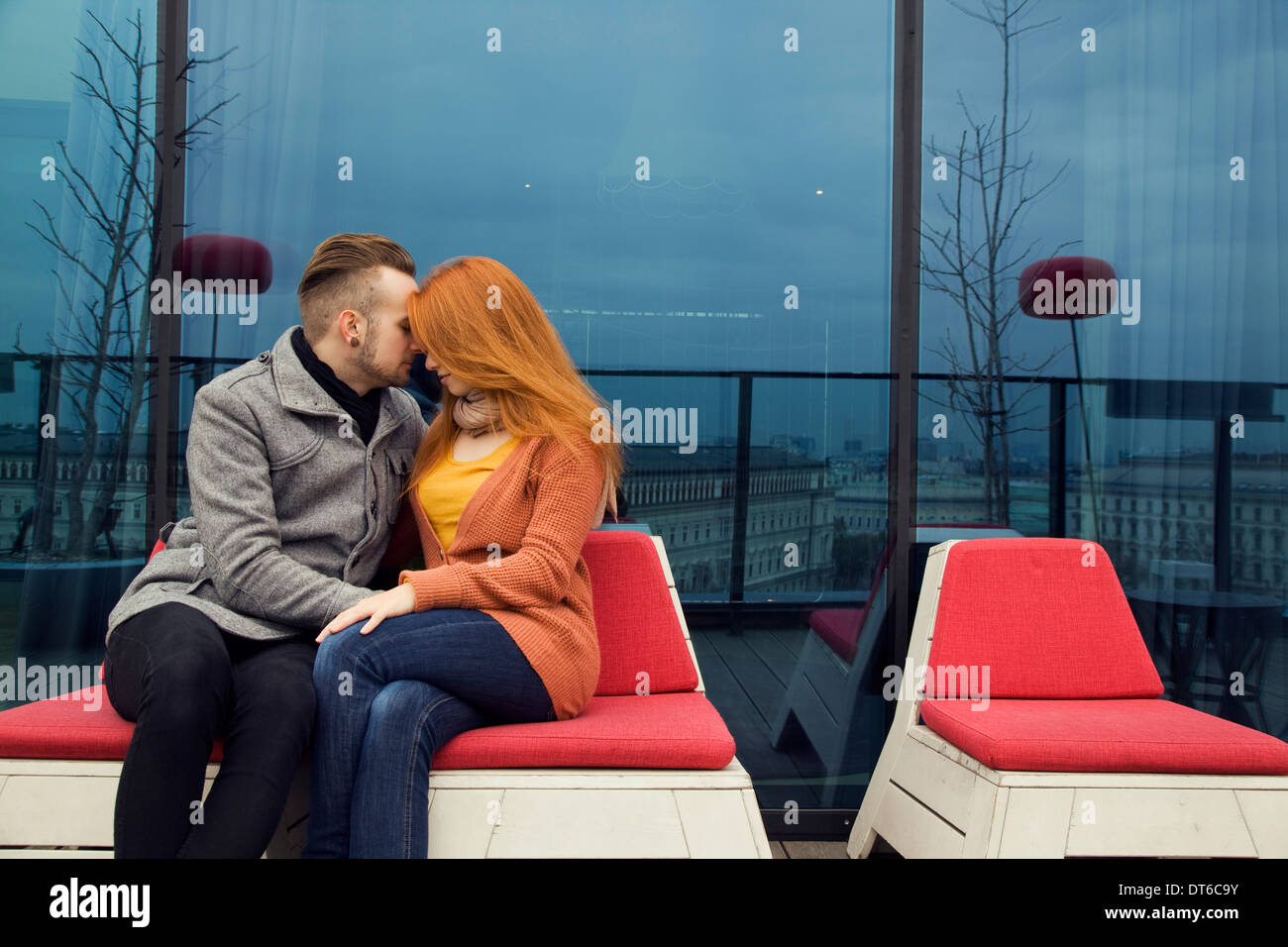 Romantic young couple sitting outdoors on rooftop terrace Stock Photo ...