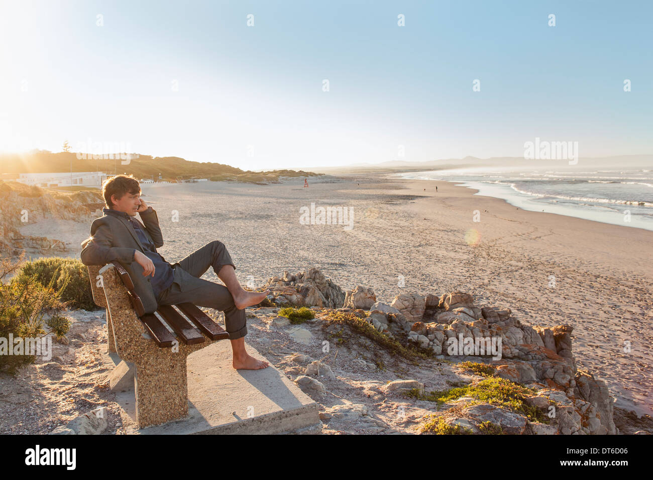 Man relaxing on beach bench Stock Photo - Alamy