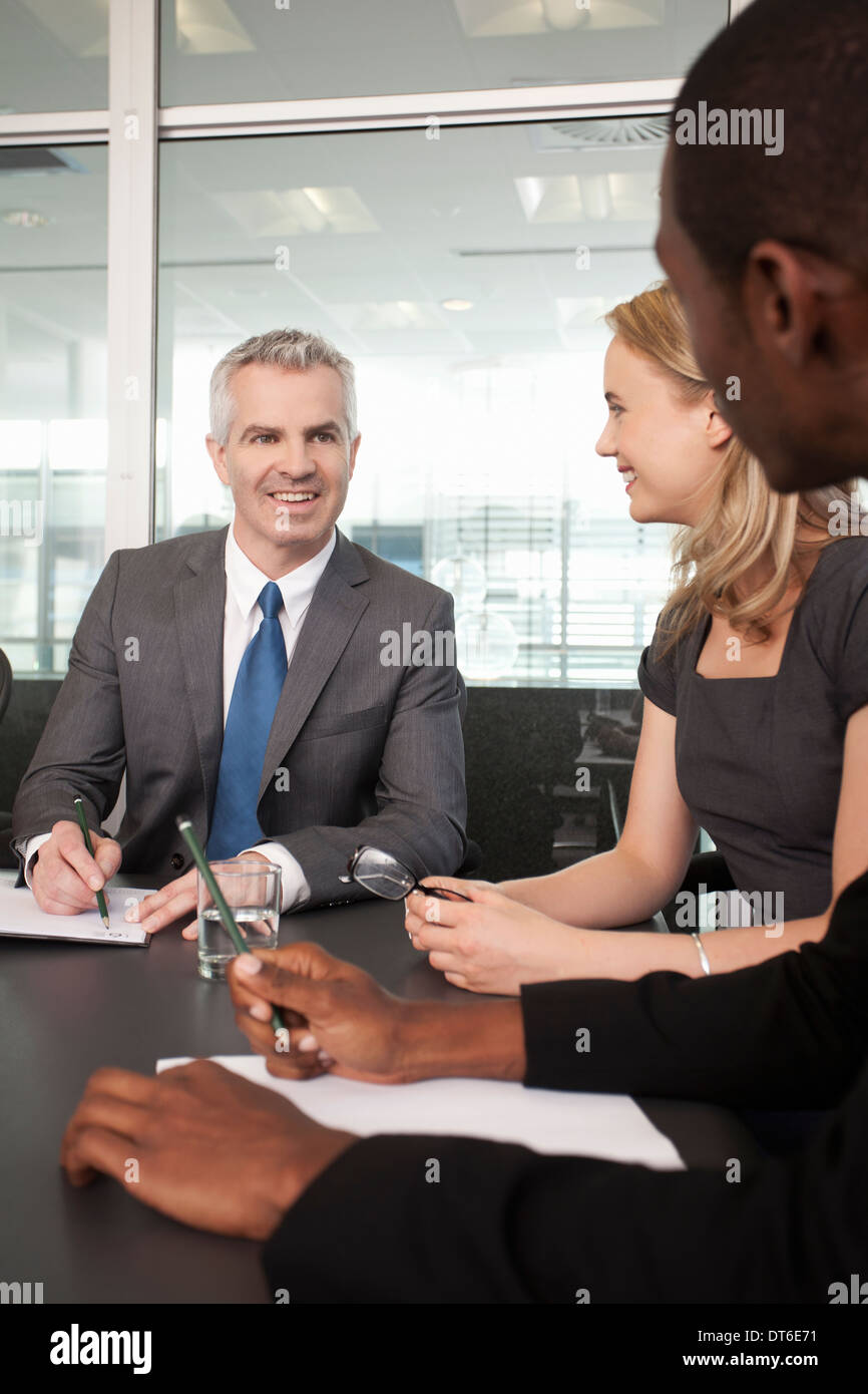 Business manager and colleagues holding meeting in office Stock Photo ...