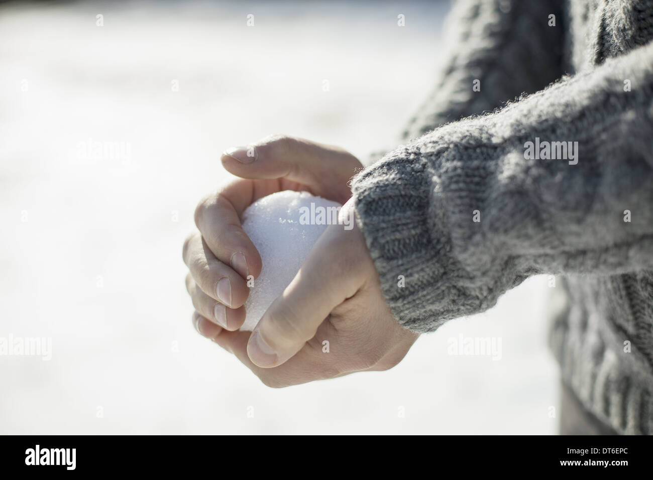 A man holding a large snowball in his bare hands Stock Photo - Alamy