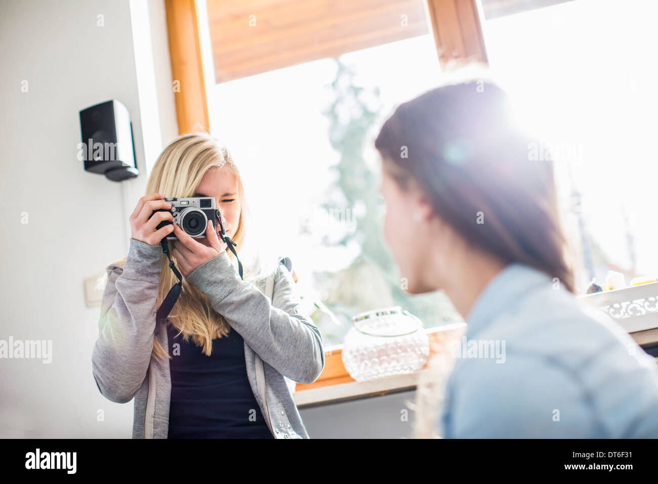 Teenage girl photographing friend with camera Stock Photo - Alamy