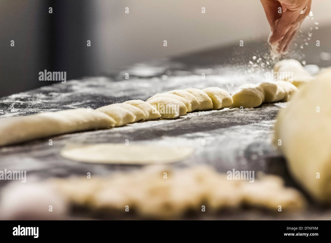 Chef's hand sprinkling flour on gnocchi in commercial kitchen Stock ...