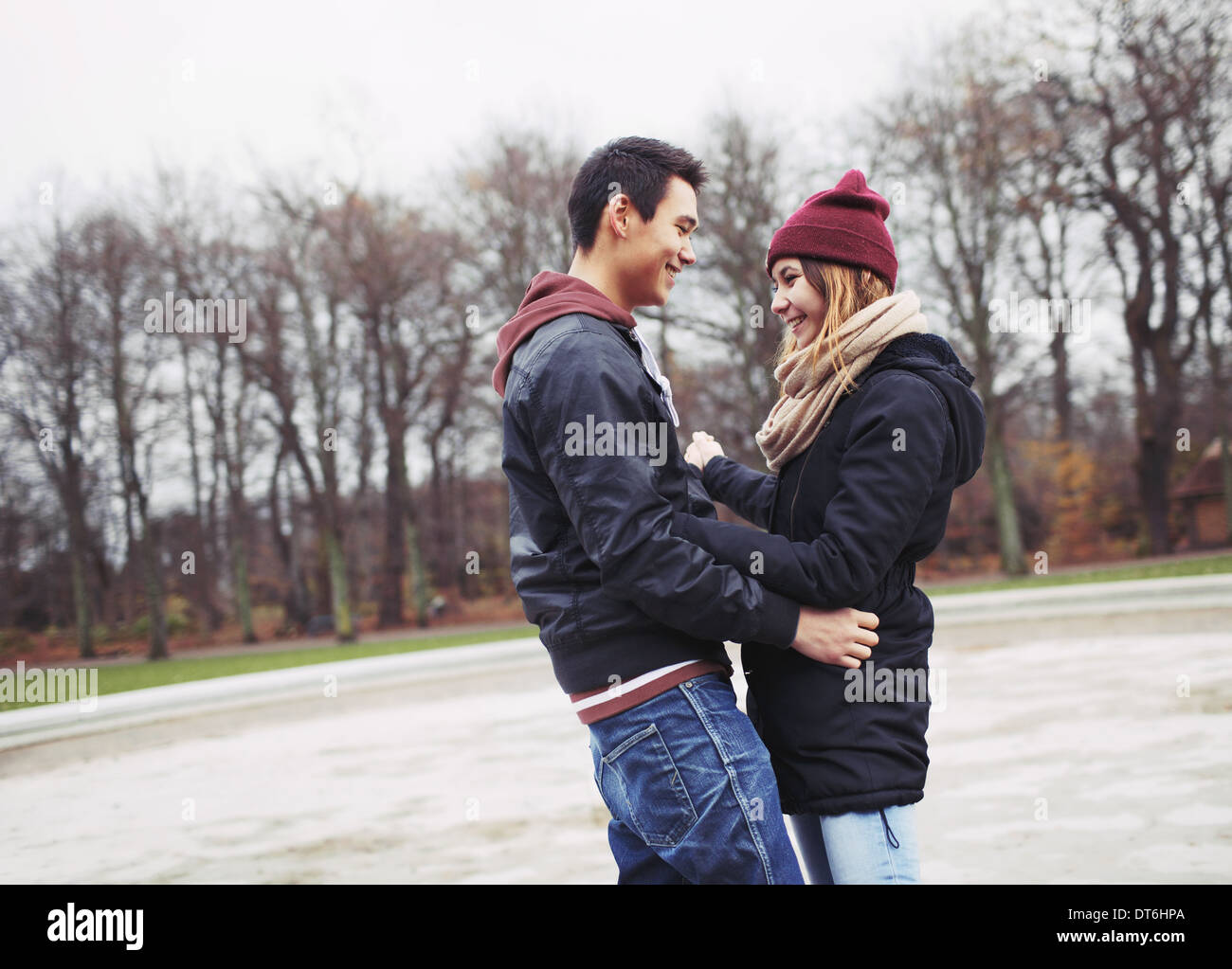 Handsome young man and beautiful woman standing together looking at ...
