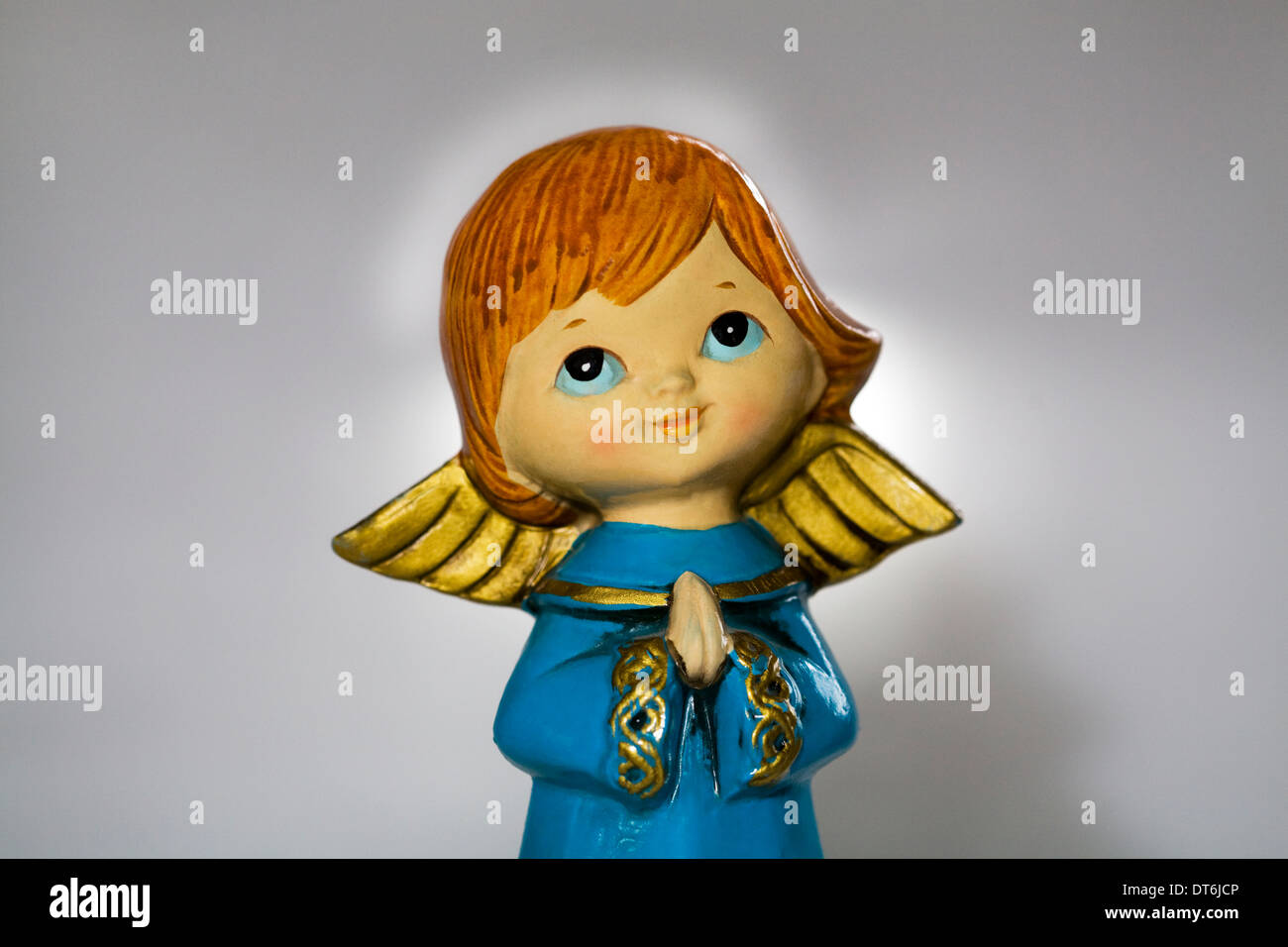 A pretty little angel with big eyes and gold wings Stock Photo - Alamy