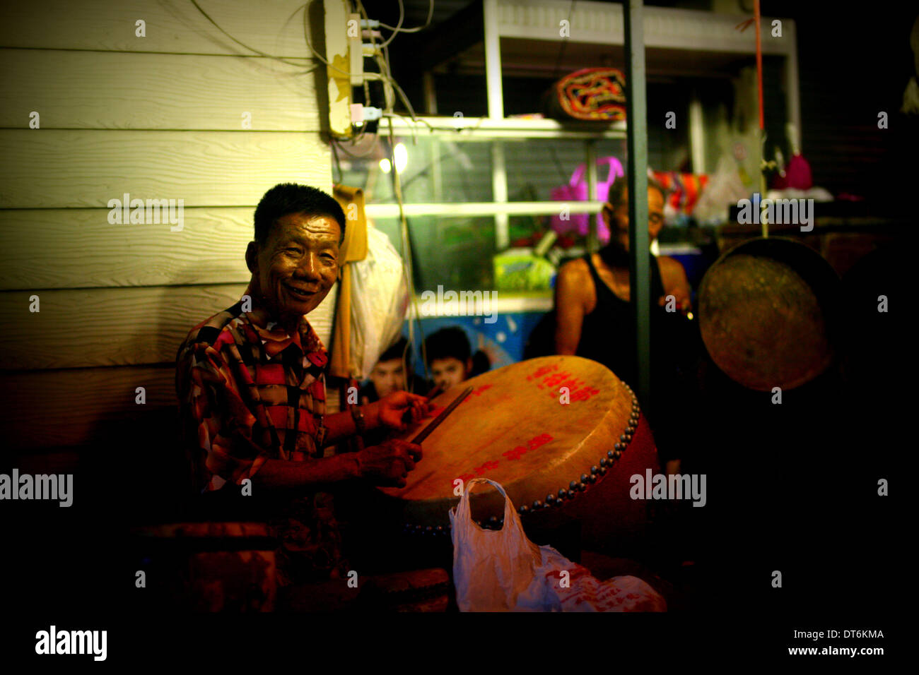 Bangkok, Thailand. 8th Feb, 2014. A man plays a traditional instrument ...