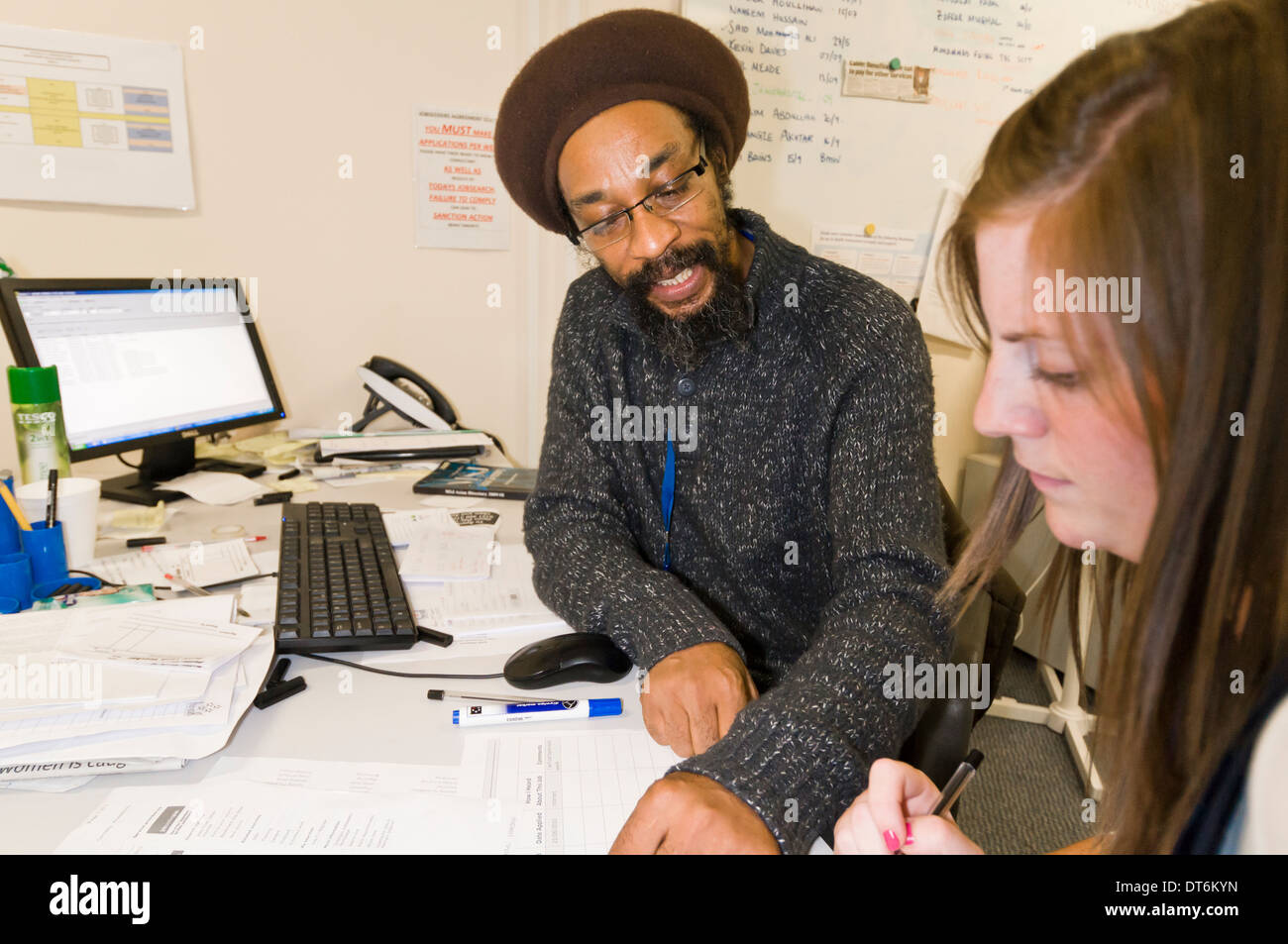 Two people sat at a desk in an office having a discussion Stock Photo ...
