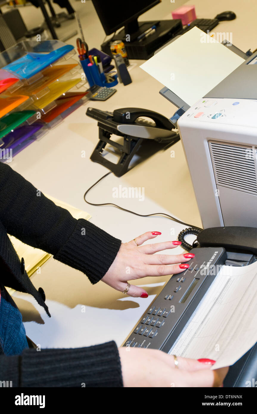 Woman in an office using a fax machine Stock Photo - Alamy