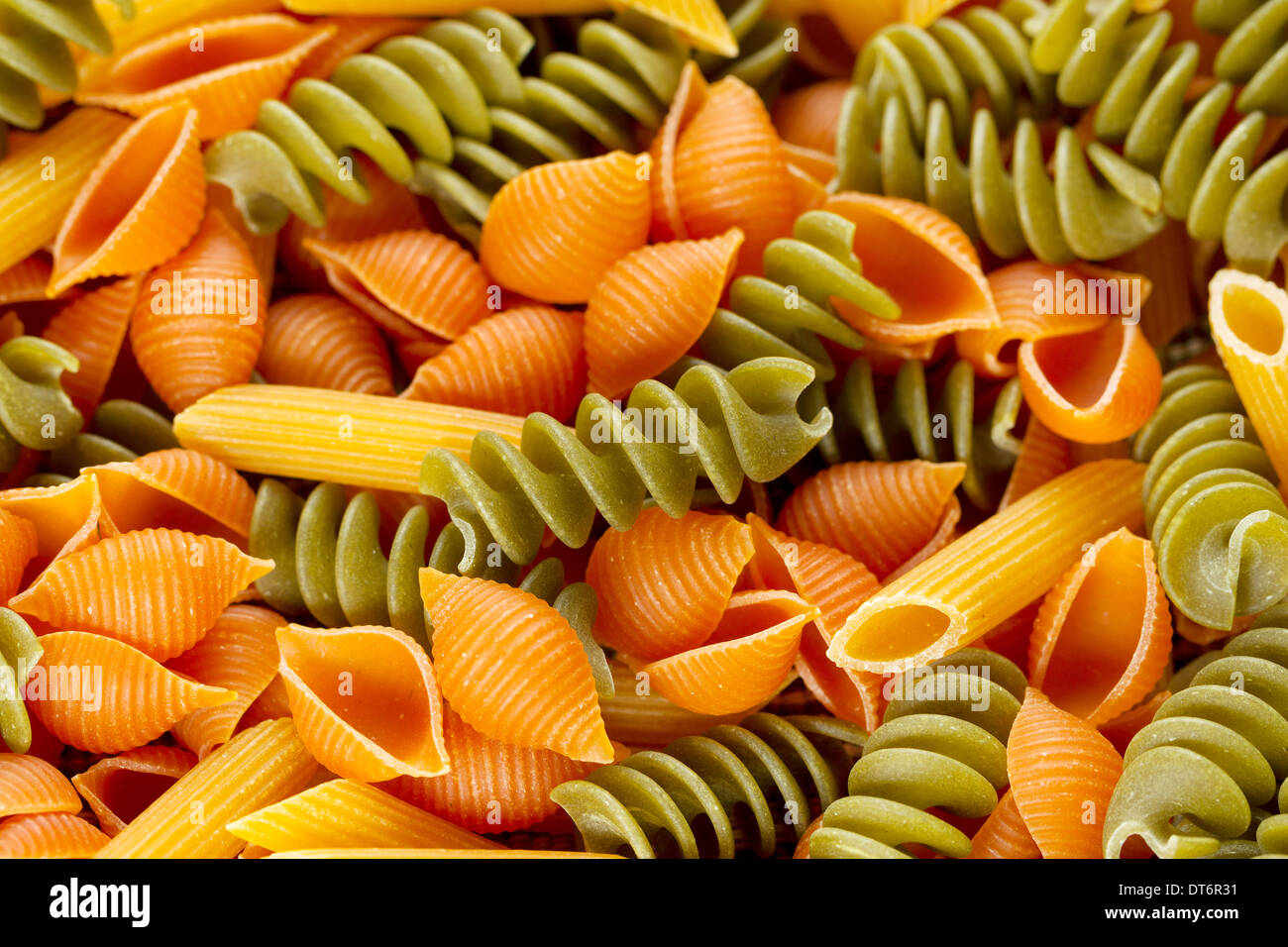 Horizontal photo of uncooked pasta, different shapes, in colors of ...