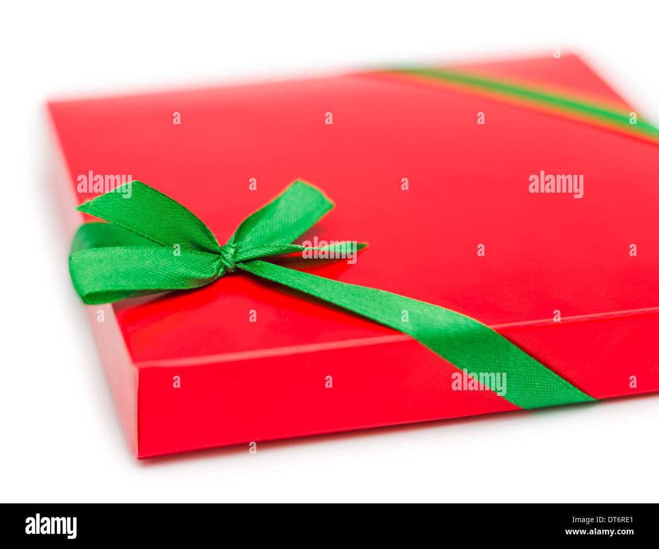 Red present box close up with green ribbon and bow isolated on white ...