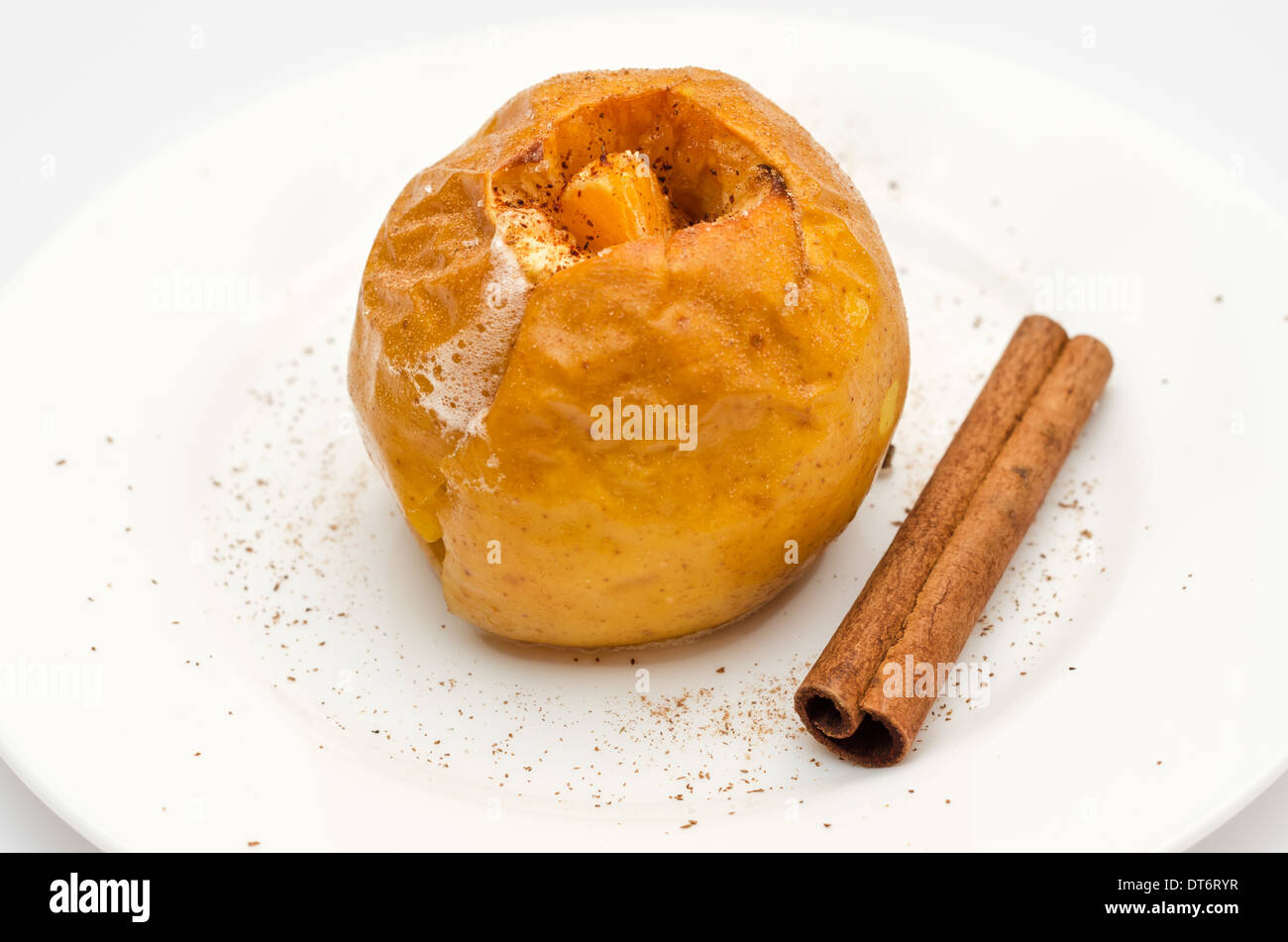 Baked apple on plate and cinnamon stick Stock Photo - Alamy