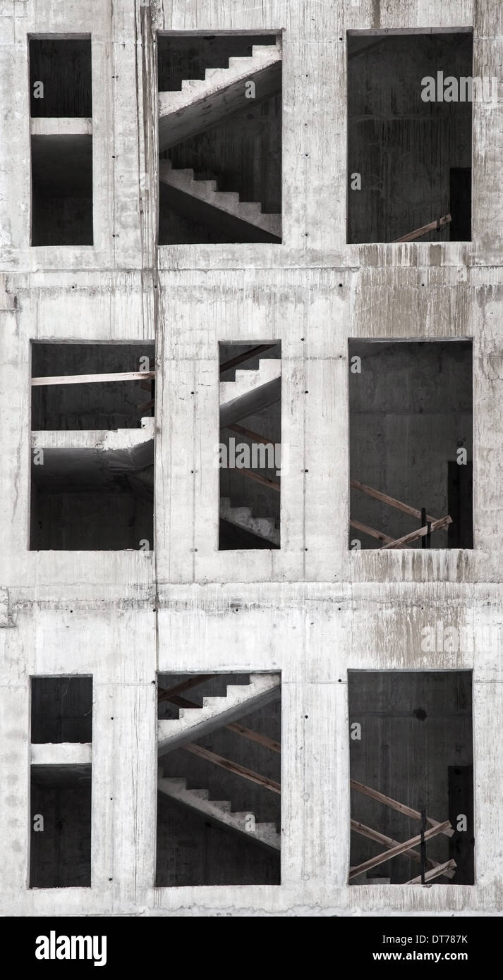 Building under construction, concrete wall with windows and stairs ...