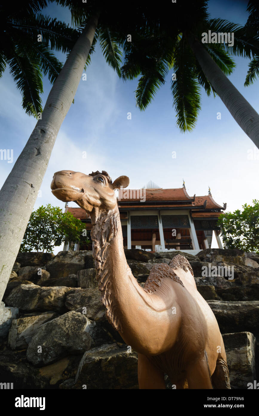 A single camel sculpture under a palm tree at Nong Nooch Tropical ...