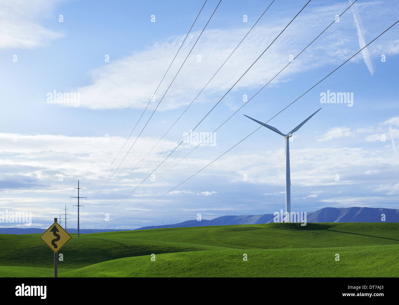 Wind turbines on a grassy hilltop road sign warning Winding Road Green ...
