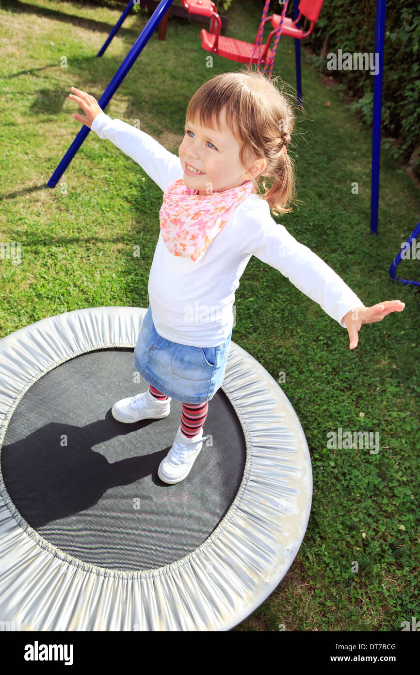 jumping girl on the trampoline in the garden Stock Photo - Alamy