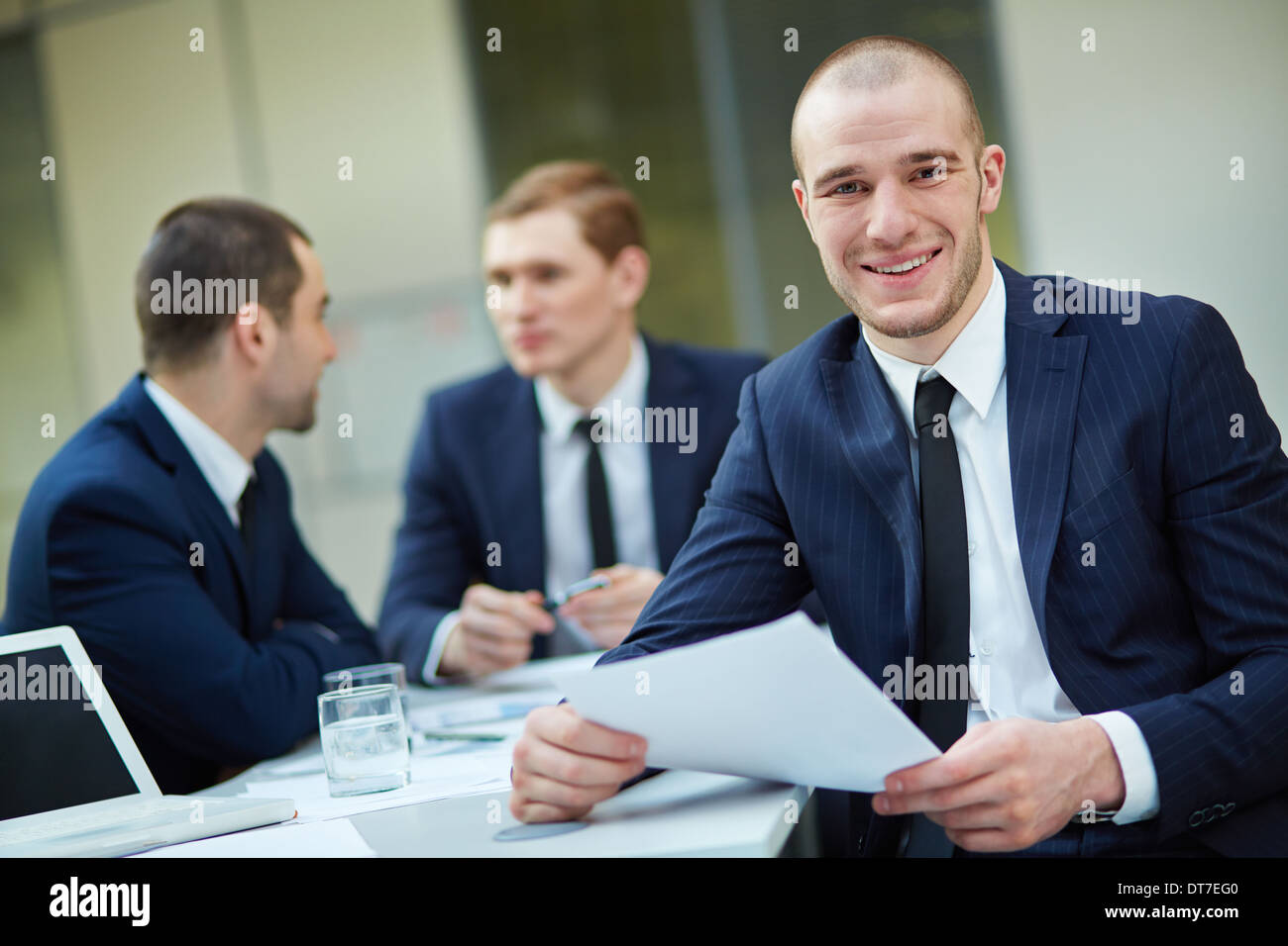 Young businessman with document looking at camera in working ...
