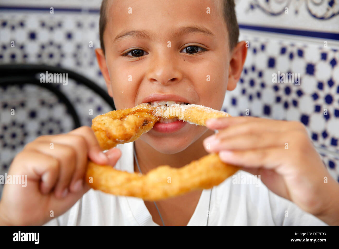 Boy eating Spanish churros Stock Photo - Alamy
