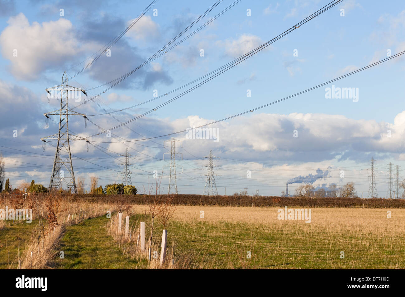 Pylons across the landscape with a power station in the distance ...