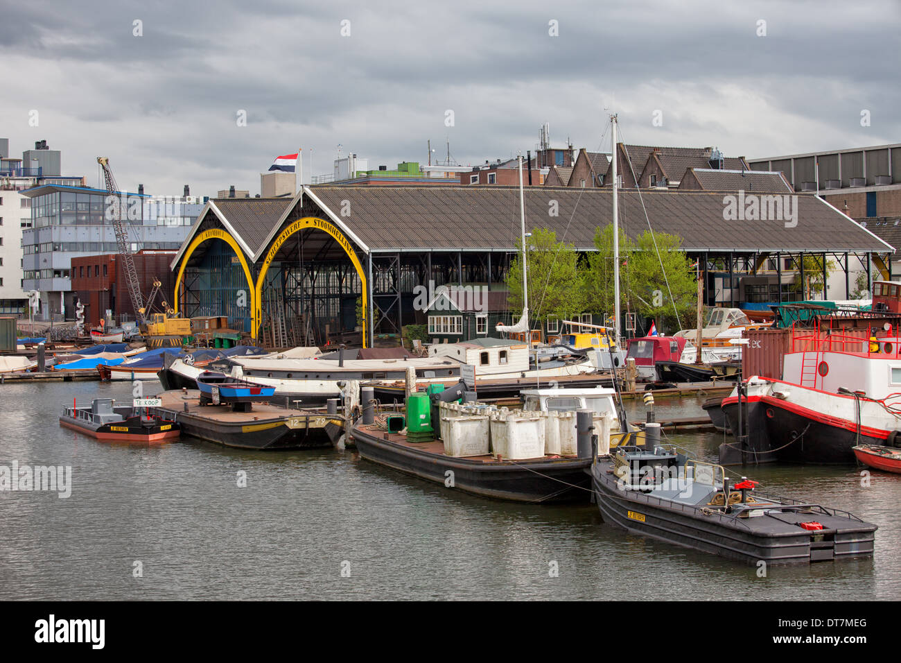 Shipyard and canal waterfront with barges, boats, ships in Amsterdam ...