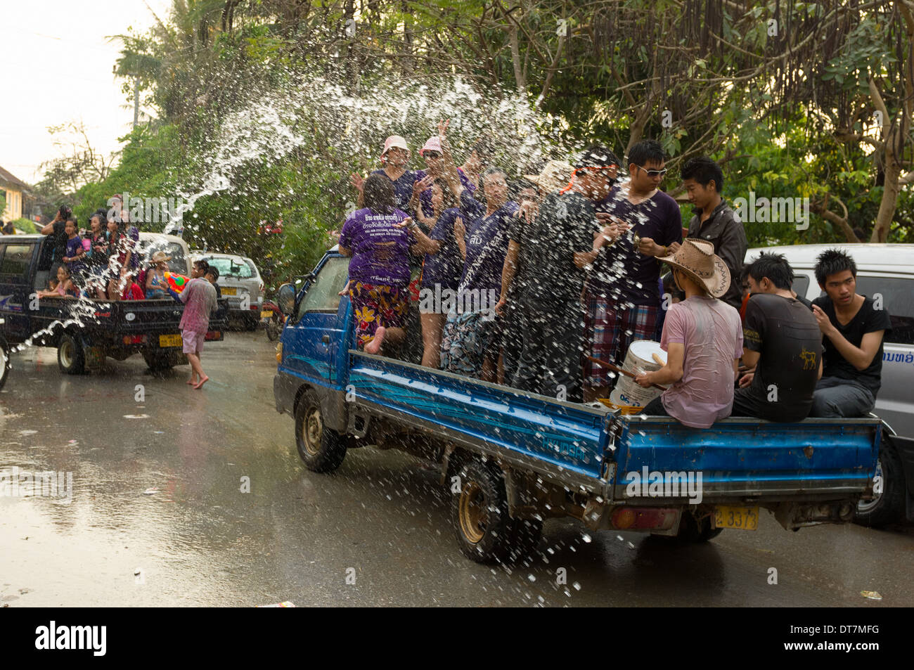 Crowded pick-up truck being hit by a plume of water, during water ...