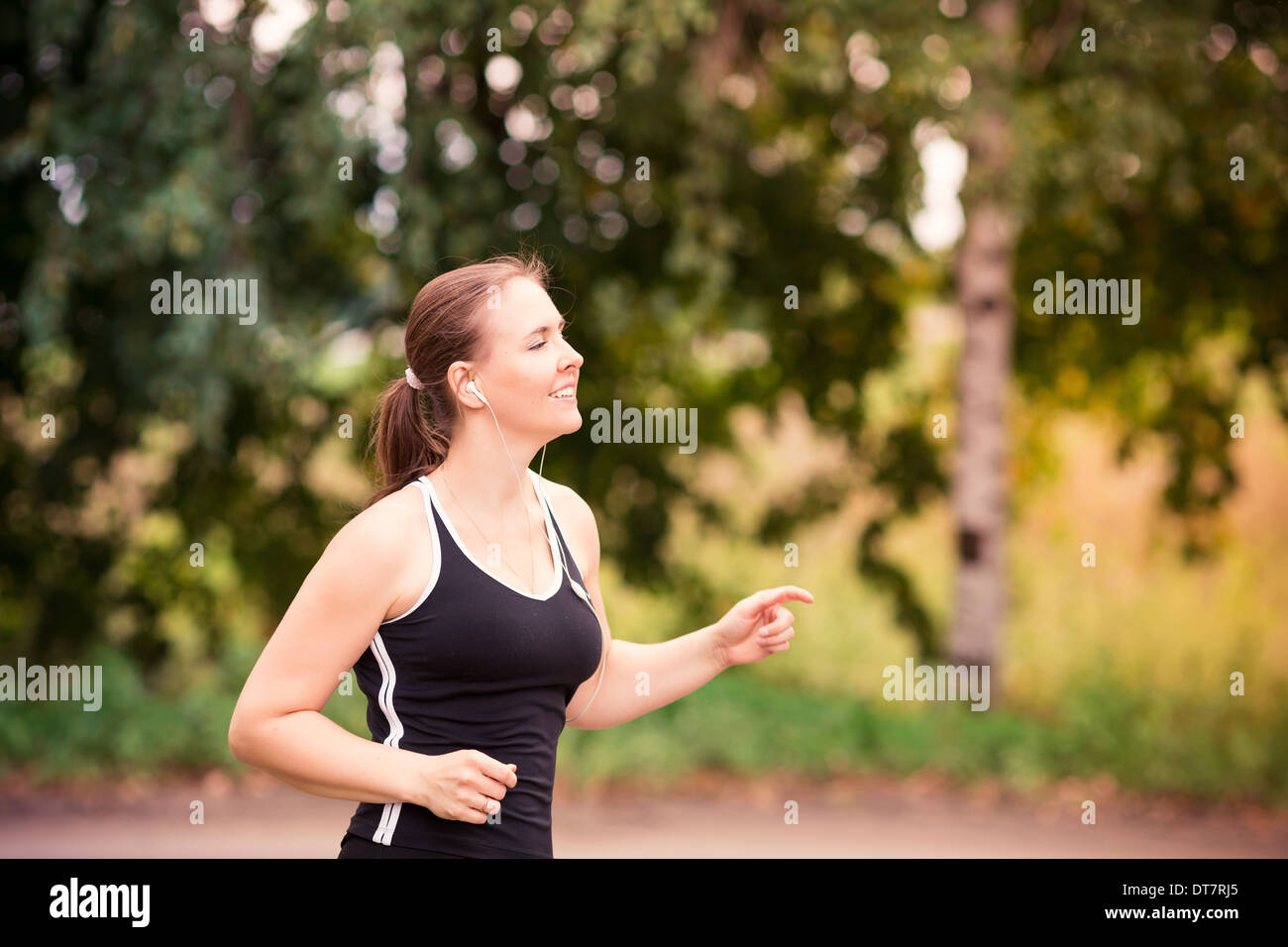 Beautiful fit runner woman jogging in nature outdoor Stock Photo - Alamy