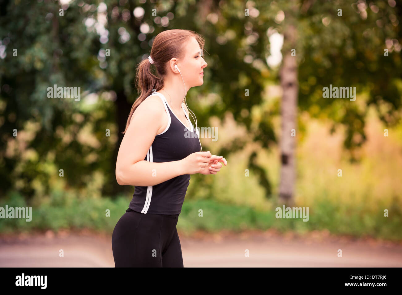 Beautiful fit runner woman jogging in nature outdoor Stock Photo - Alamy
