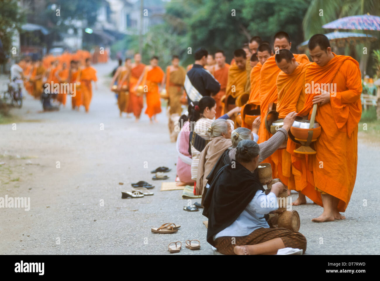 Buddhist monks receiving alms on their morning alms round on Khem Khong ...