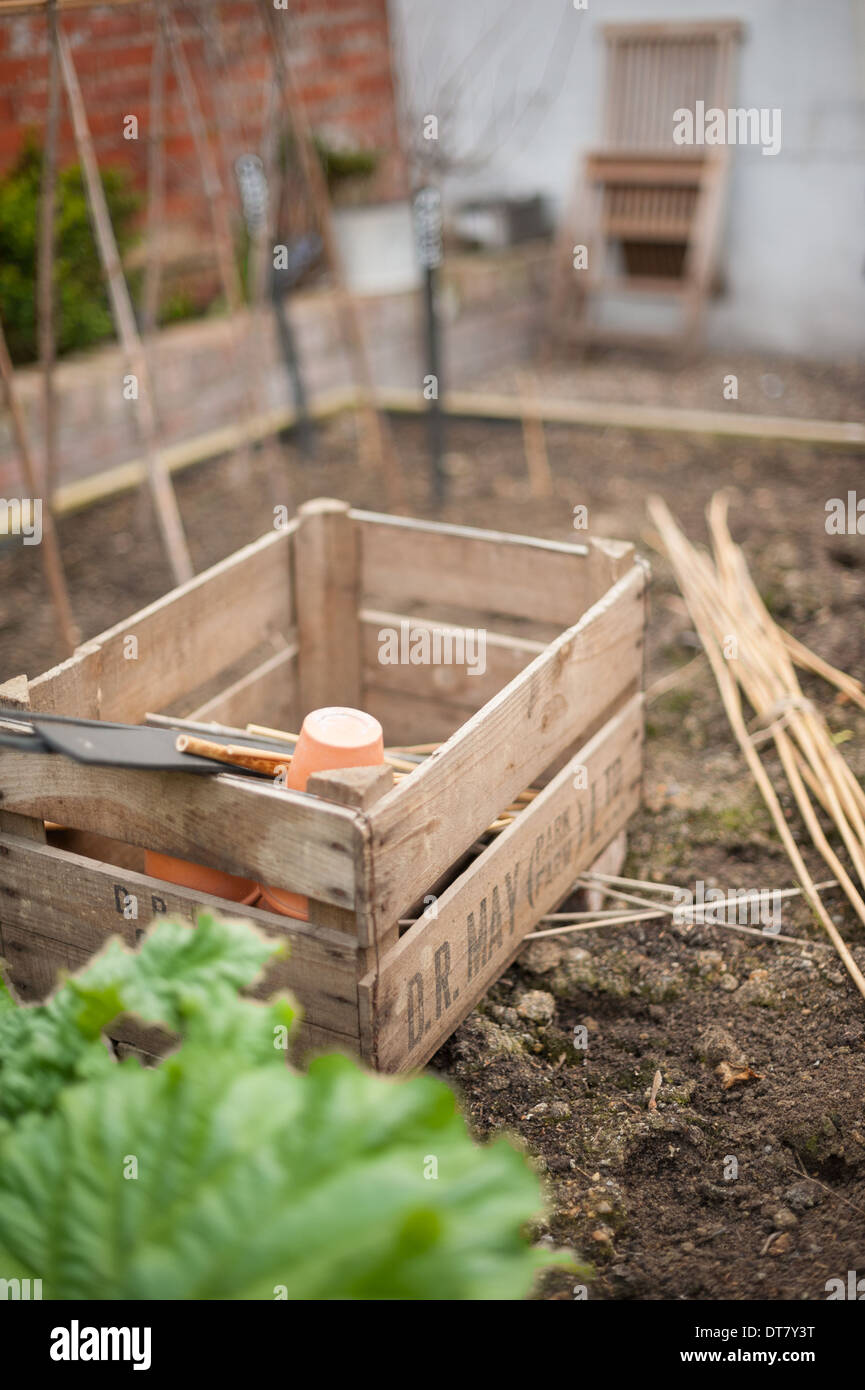 Gardening tools in wooden box with vegetable patch Stock Photo - Alamy